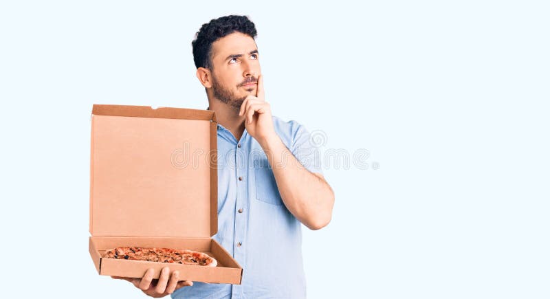 Young Hispanic Man Holding Delivery Pizza Box Serious Face Thinking ...