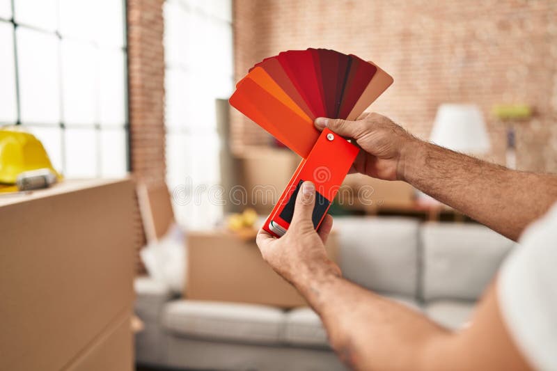 Young Hispanic Man Holding Paint Color Test at New Home Stock Photo ...