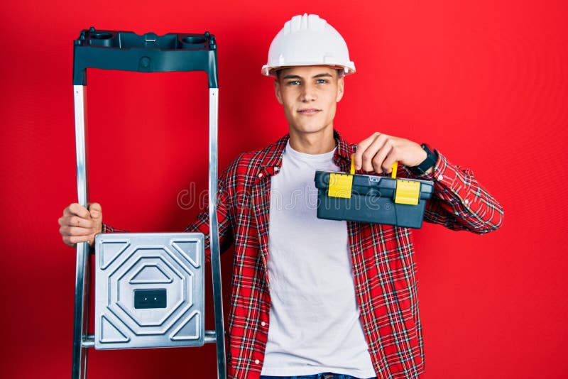 Young Hispanic Man Holding Tools Box Wearing Hardhat by Construction ...