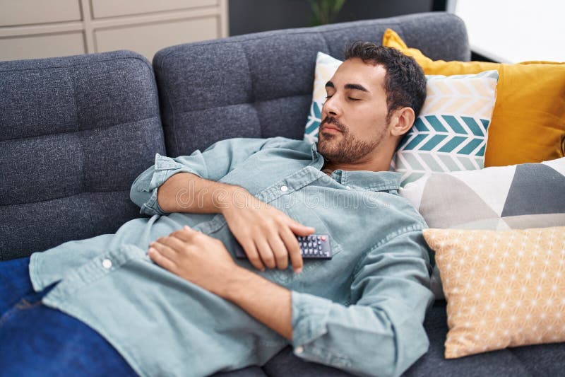 Young Hispanic Man Holding Tv Remote Control Lying on Sofa Sleeping at ...