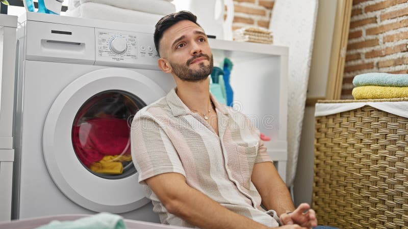 Young Hispanic Man Leaning on Washing Machine Stressed at Laundry Room ...