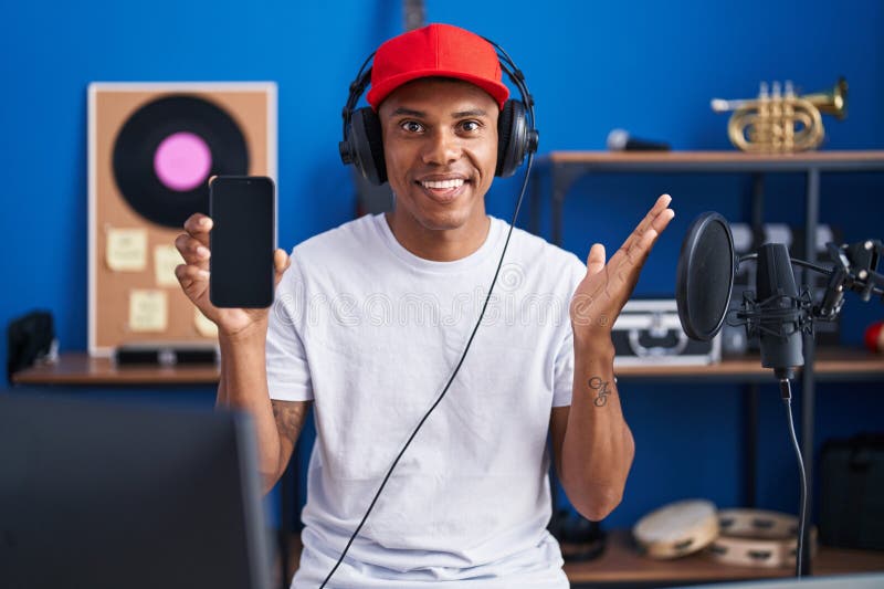 Young Hispanic Man Listening To Music Wearing Headphones Showing