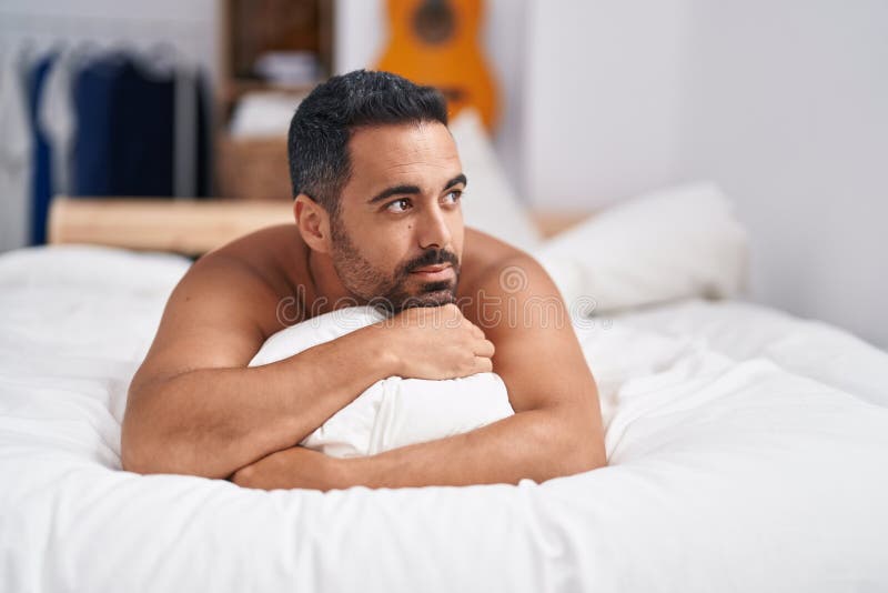 Young Hispanic Man Lying on Bed with Relaxed Expression at Bedroom ...