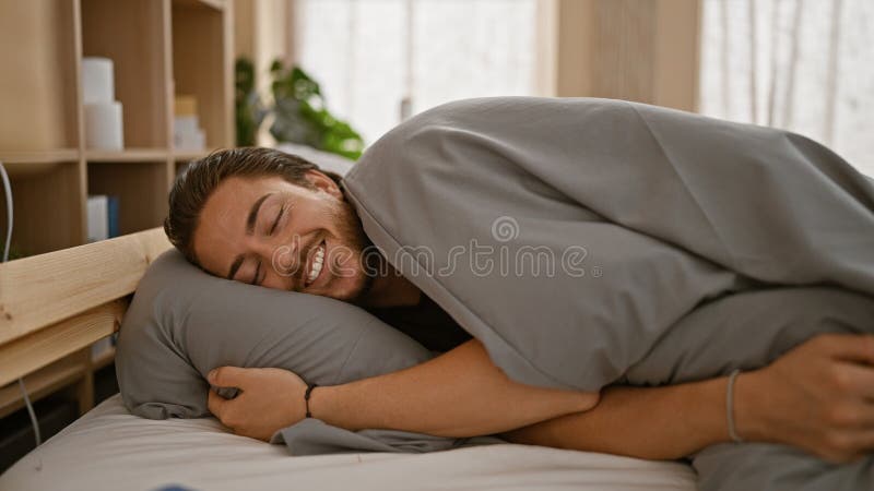 Young Hispanic Man Lying on Bed Smiling To Sleep at Bedroom Stock Photo ...