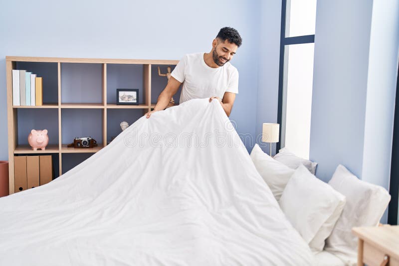 Young Hispanic Man Make Bed Standing at Bedroom Stock Image - Image of ...