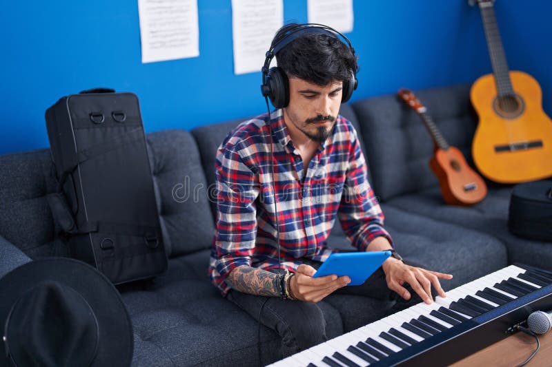Young Hispanic Man Musician Playing Piano Keyboard Using Touchpad at ...