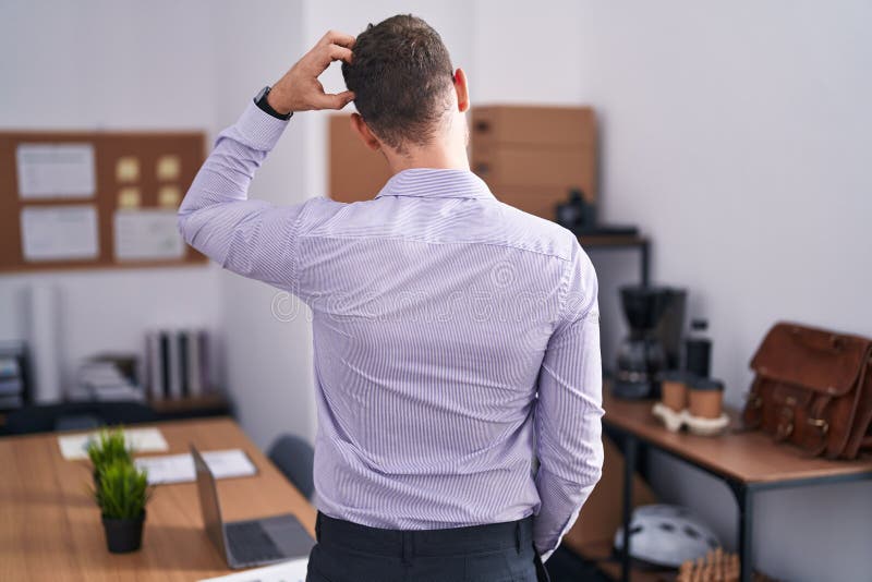 Young Hispanic Man at the Office Backwards Thinking about Doubt with ...