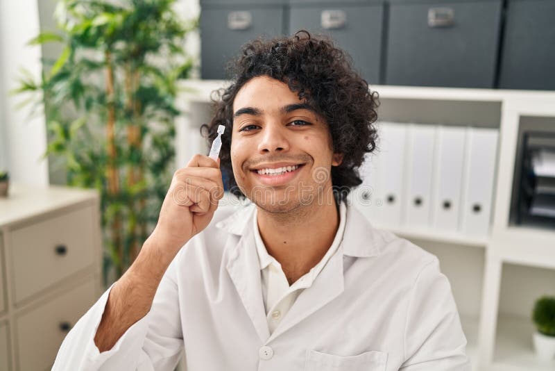 Young Hispanic Man Optician Holding Eye Drop at Clinic Stock Photo ...