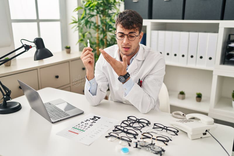 Young Hispanic Man Optician Holding Eye Drops at Clinic Stock Image ...