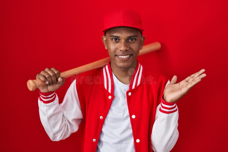 Young Hispanic Man Playing Baseball Holding Bat Pointing Aside with ...