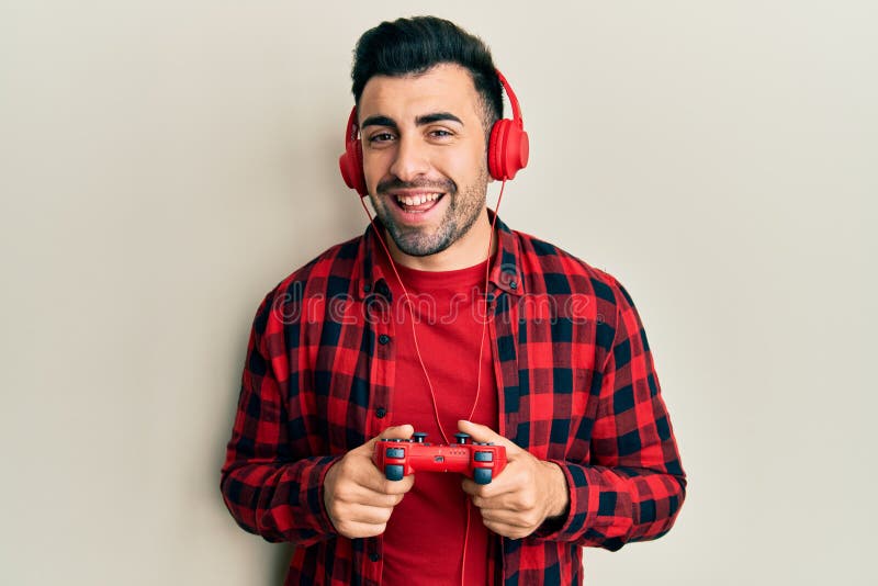Young Hispanic Man Playing Video Game Holding Controller Smiling with a ...