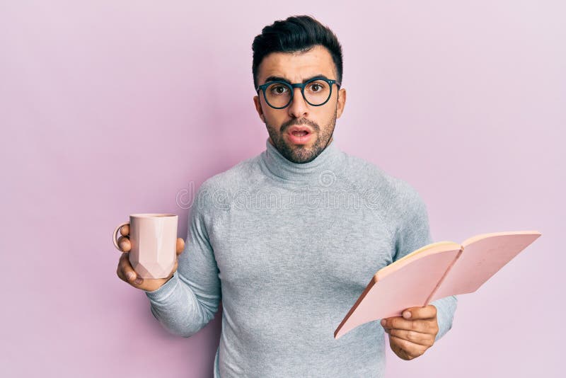 Young Hispanic Man Reading a Book and Drinking a Cup of Coffee in Shock ...