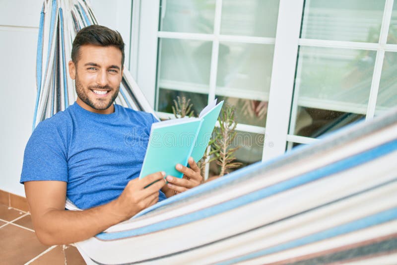 Young Hispanic Man Relaxed Reading Book Lying on the Hammock at Terrace ...