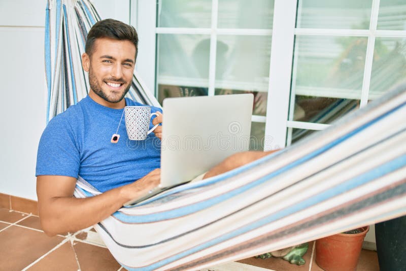 Young Hispanic Man Relaxed Working Using Laptop and Drinking Coffee ...