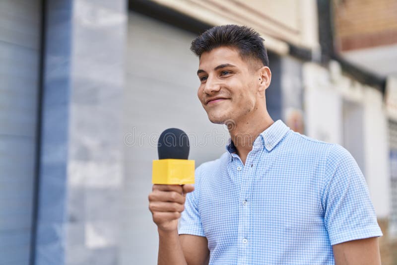 Young Hispanic Man Reporter Working Using Microphone at Street Stock ...