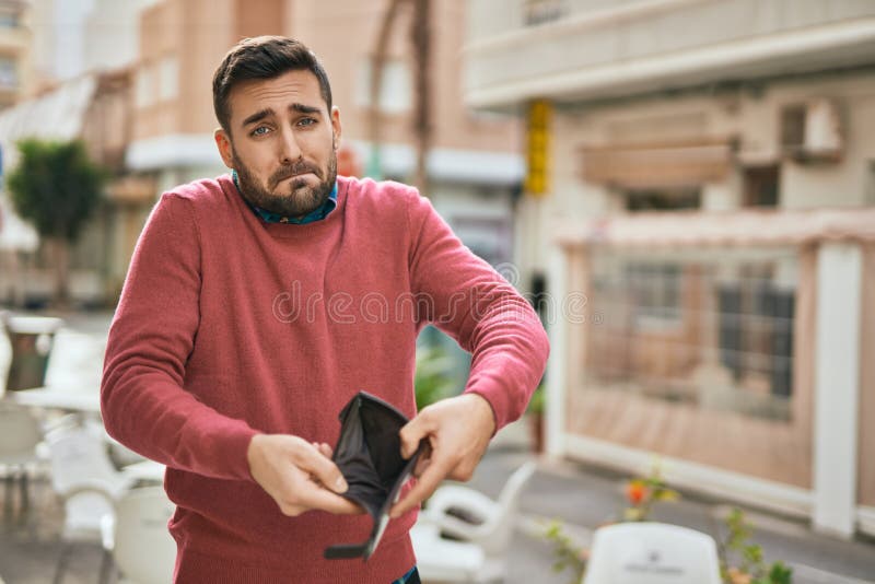 Young Hispanic Man with Sad Expression Showing Empty Wallet at the City ...