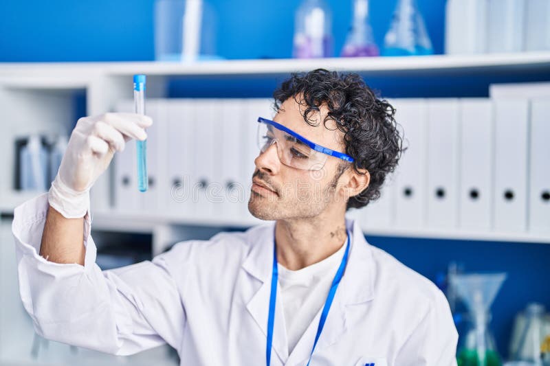 Young Hispanic Man Scientist Holding Test Tube at Laboratory Stock ...