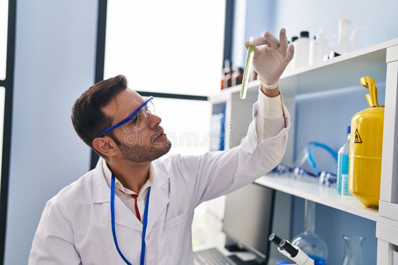 Young Hispanic Man Scientist Looking Test Tube at Laboratory Stock ...