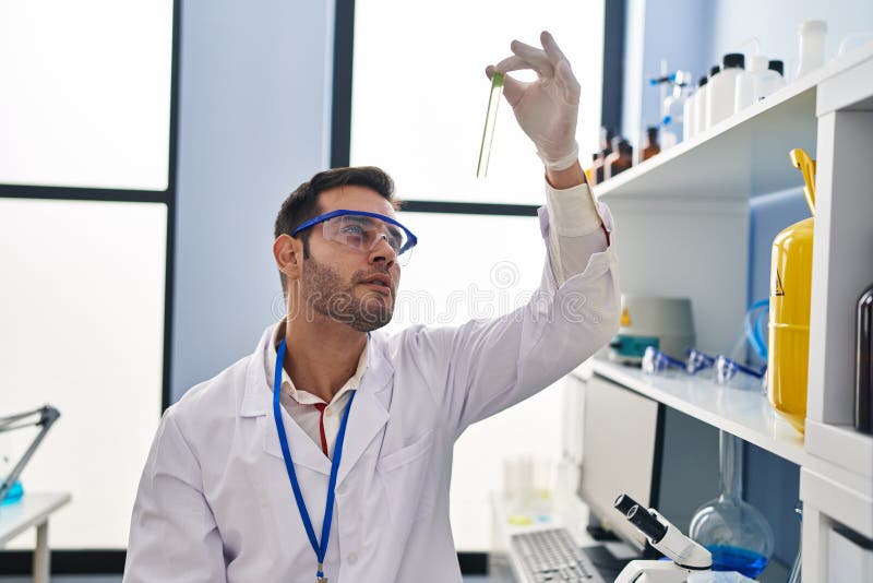 Young Hispanic Man Scientist Looking Test Tube at Laboratory Stock ...