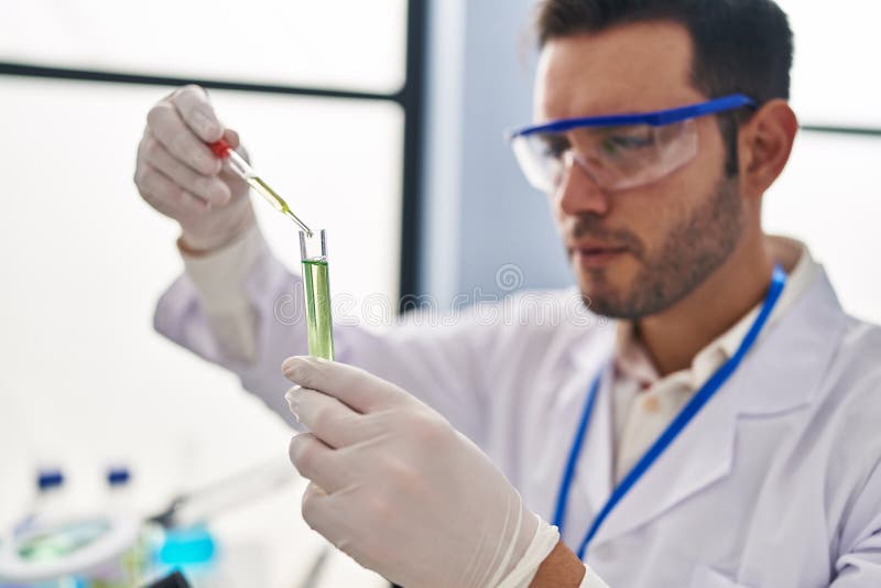 Young Hispanic Man Scientist Measuring Liquid at Laboratory Stock Photo ...