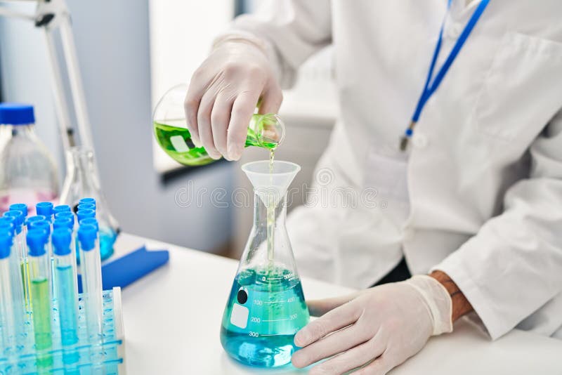 Young Hispanic Man Scientist Measuring Liquid at Laboratory Stock Image ...