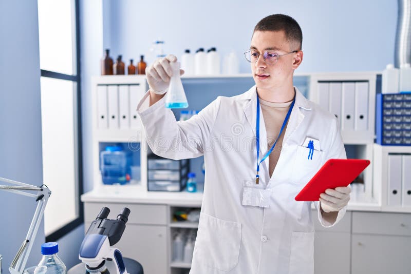 Young Hispanic Man Scientist Measuring Liquid Using Touchpad at ...