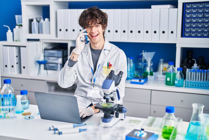 Young Hispanic Man Scientist Talking on the Smartphone Using Laptop at ...