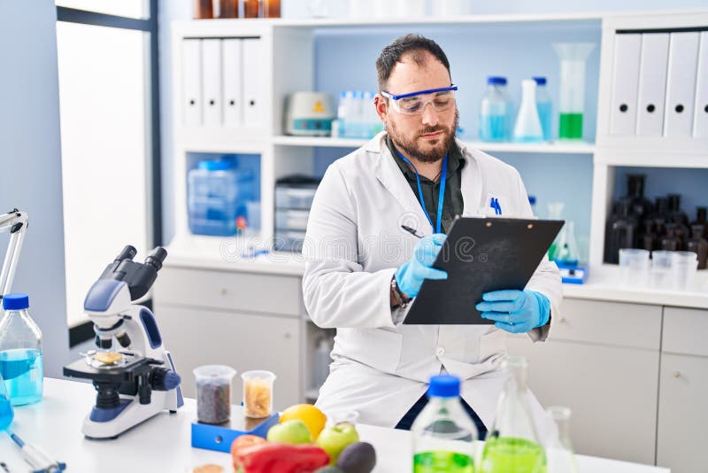 Young Hispanic Man Scientist Write on Report Working at Laboratory ...