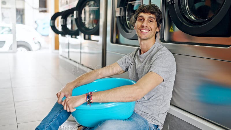 Young Hispanic Man Sitting on Floor Leaning on Washing Machine at ...