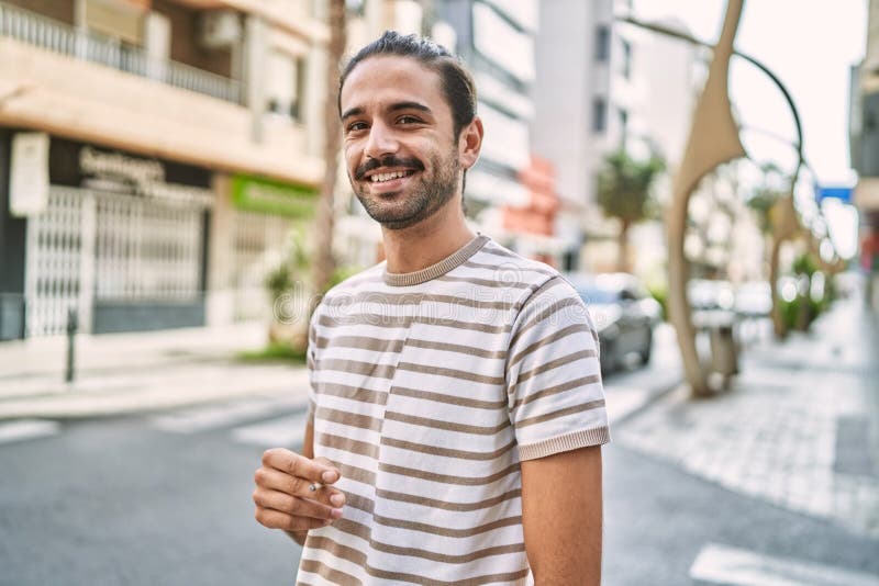 Young Hispanic Man Smiling Confident Smoking Cigarette at Street Stock ...