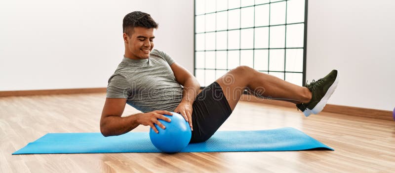 Young Hispanic Man Smiling Confident Training Abs Exercise Using Ball ...