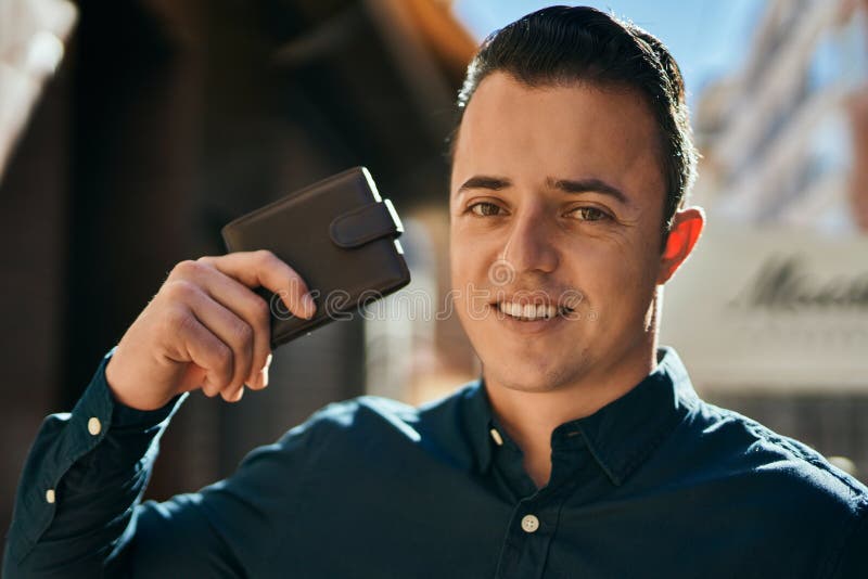 Young Hispanic Man Smiling Happy Holding Wallet at the City Stock Photo ...