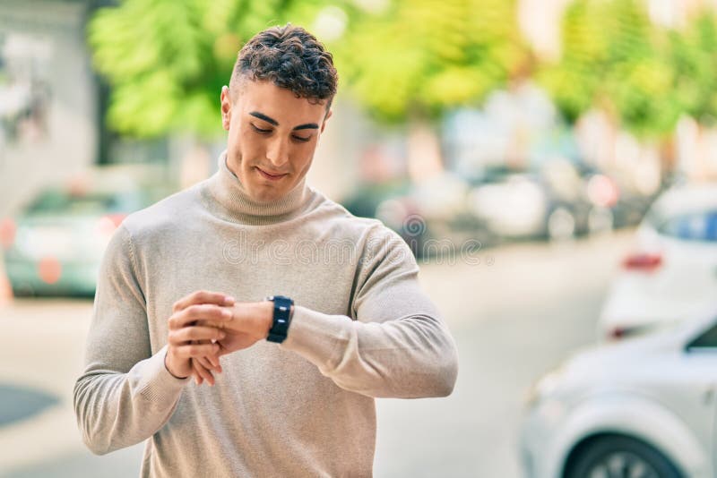 Young Hispanic Man Smiling Happy Using Watch at the City Stock Image ...