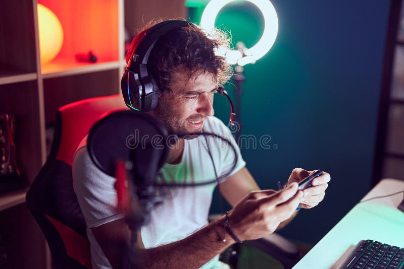 Young Hispanic Man Streamer Playing Video Game Using Smartphone at ...