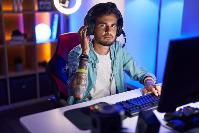 Young Hispanic Man Streamer Sitting on Table with Relaxed Expression at ...