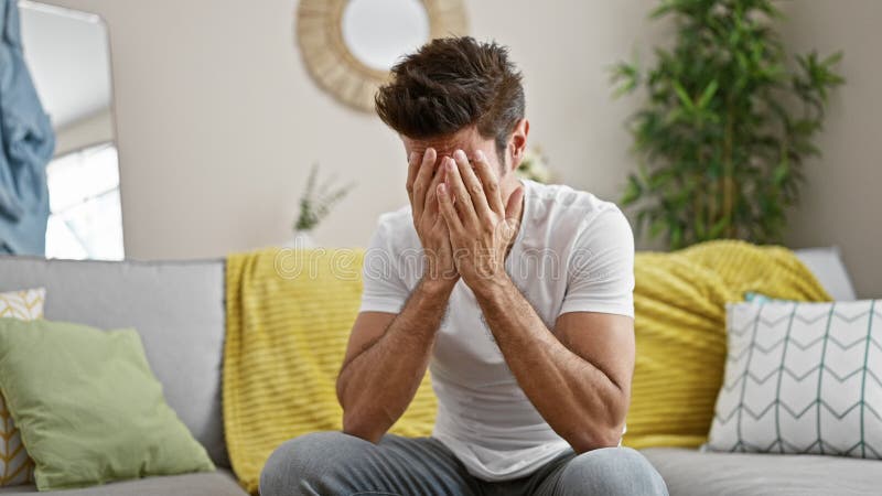 Young Hispanic Man Stressed Sitting on Sofa Crying at Home Stock ...