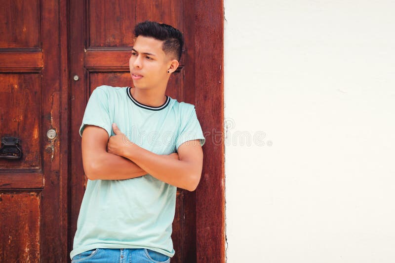 Young Hispanic Man Thinking with Crossed Hands Against the Door and ...