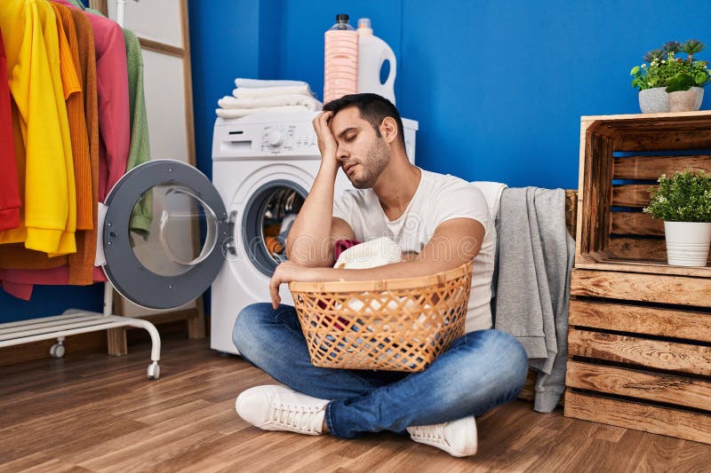 Young Hispanic Man Tired Washing Clothes at Laundry Room Stock Photo ...