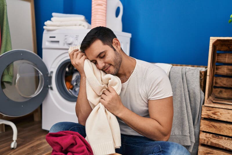 Young Hispanic Man Touching Face with Soft Clothes at Laundry Room ...