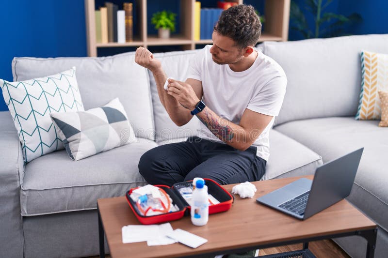 Young Hispanic Man Using First Aid Kit for Wound at Home Stock Image ...