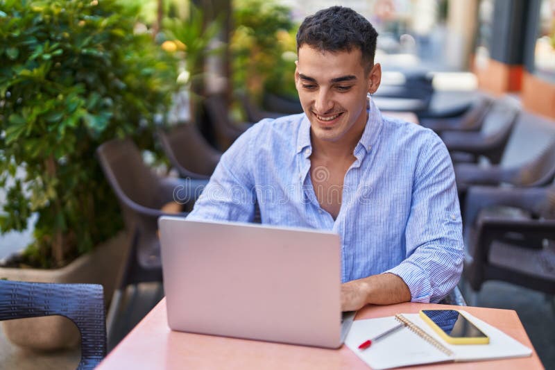 Young Hispanic Man Using Laptop Sitting on Table at Coffee Shop Terrace ...