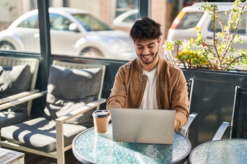 Young Hispanic Man Using Laptop Sitting on Table at Coffee Shop Terrace ...
