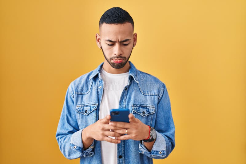 Young Hispanic Man Using Smartphone Typing Message Depressed and Worry ...