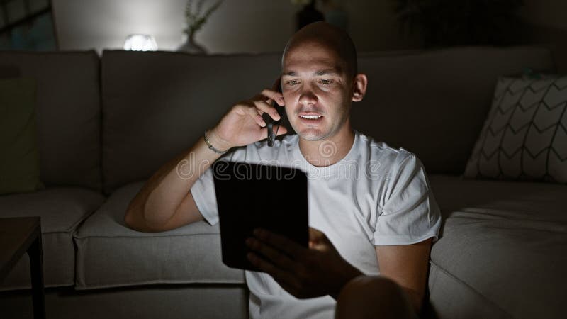Young Hispanic Man Using Touchpad Talking on Smartphone Sitting on ...