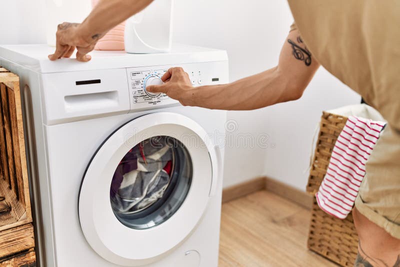 Young Hispanic Man Using Washing Machine at Laundry Room Stock Photo ...