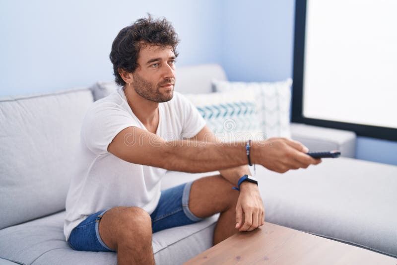 Young Hispanic Man Watching Movie Sitting on Sofa at Home Stock Image ...