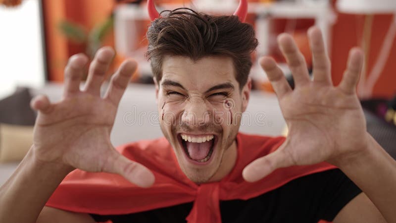 Young Hispanic Man Wearing Devil Costume Doing Scare Gesture at Home ...