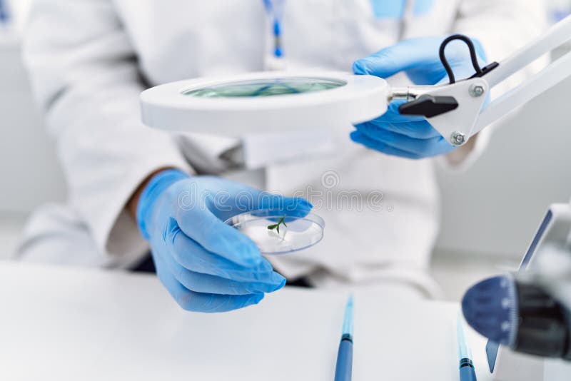 Young Hispanic Man Wearing Scientist Uniform Using Loupe at Laboratory ... Young Hispanic Man Wearing Scientist Uniform Using Loupe at Laboratory ...