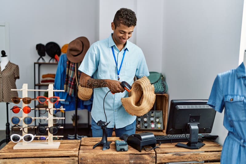 Young Hispanic Man Working As Shop Assistant Selling Hat at Retail Shop ...