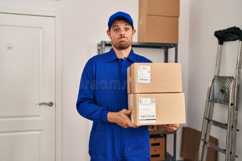 Young Hispanic Man Working on Moving Service Holding Boxes Depressed ...